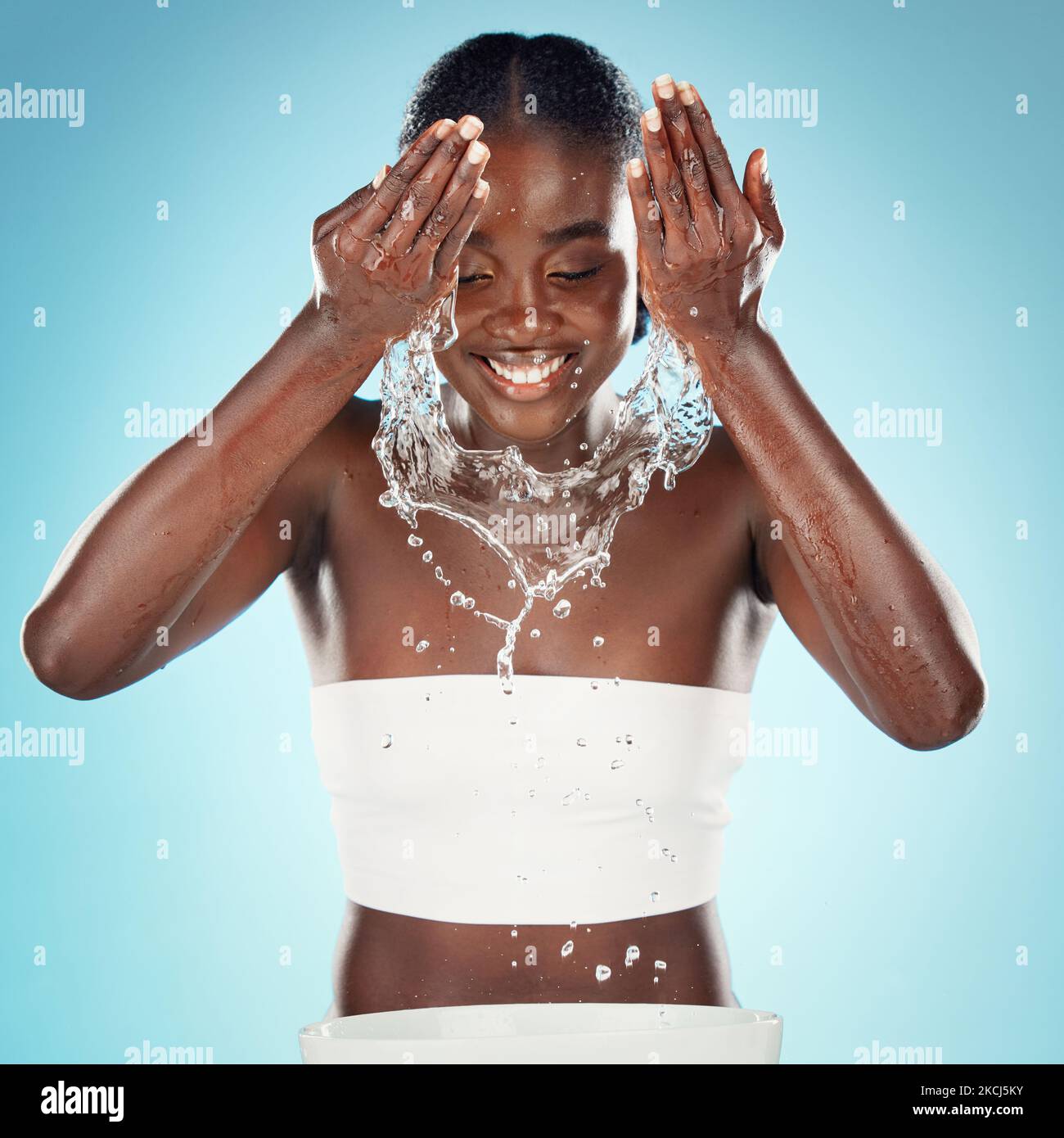 Happy woman, water splash and face cleaning, skincare and hygiene for fresh body, wellness and ...