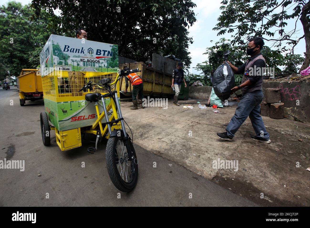 A Man carry a garbage bag non-organic into a eco-friendly electric ...