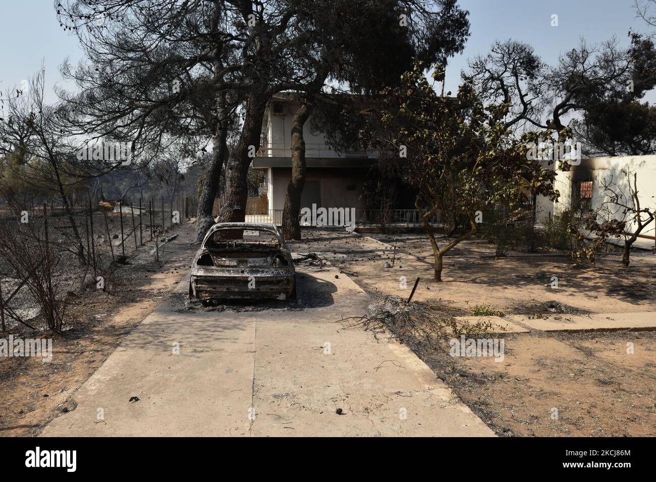 A car is destroyed in front of a damaged house in the northern suburb ...