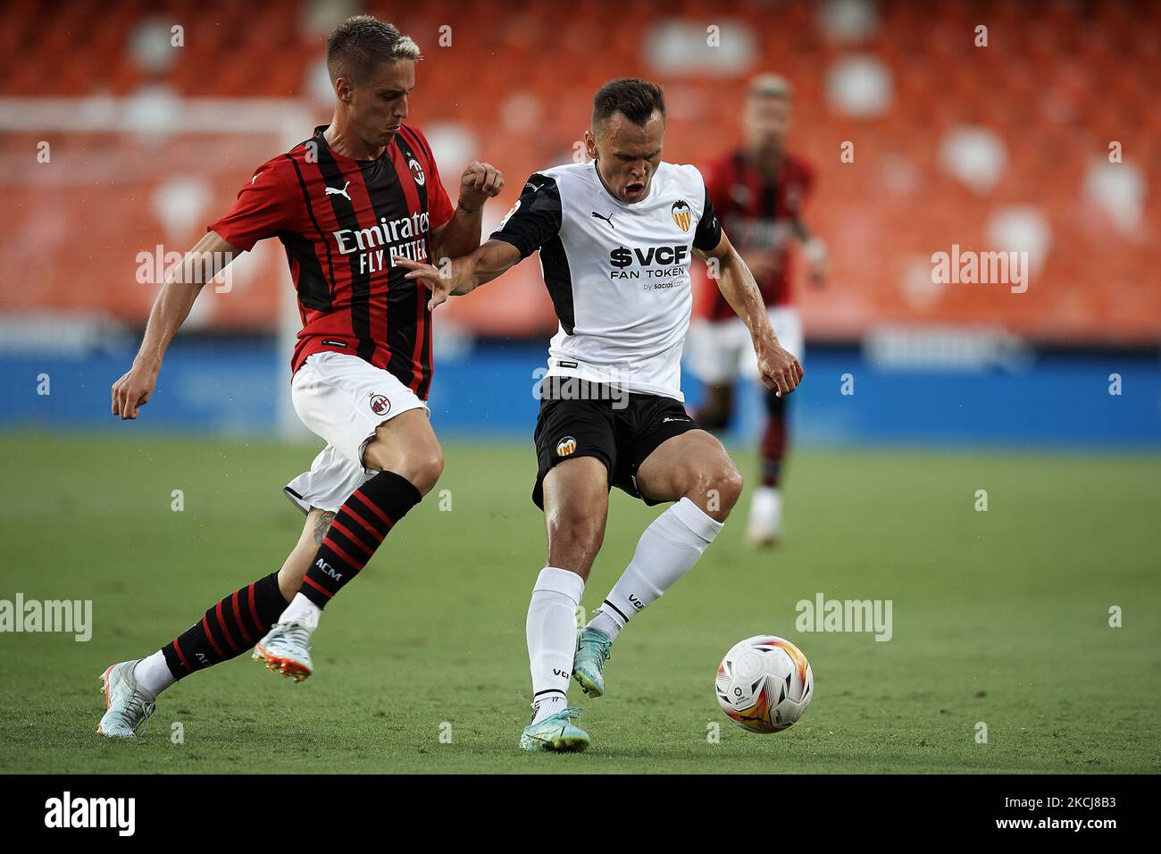 Denis Cheryshev of Valencia and Andrea Conti of Milan compete for the ...