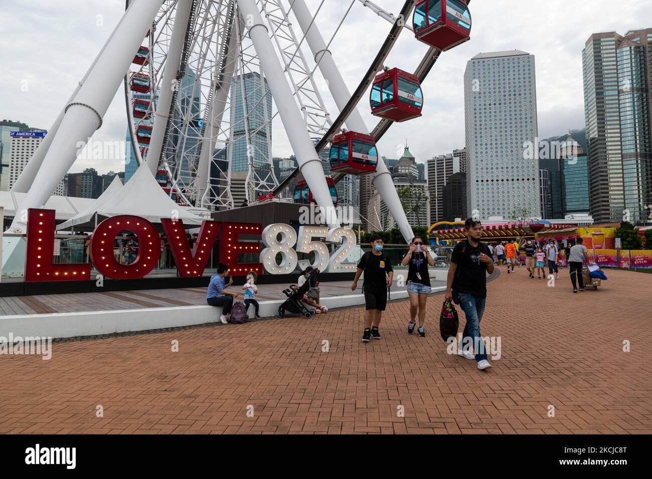 People relax near the Ferris Wheel of Hong Kong in Central on August 7 ...