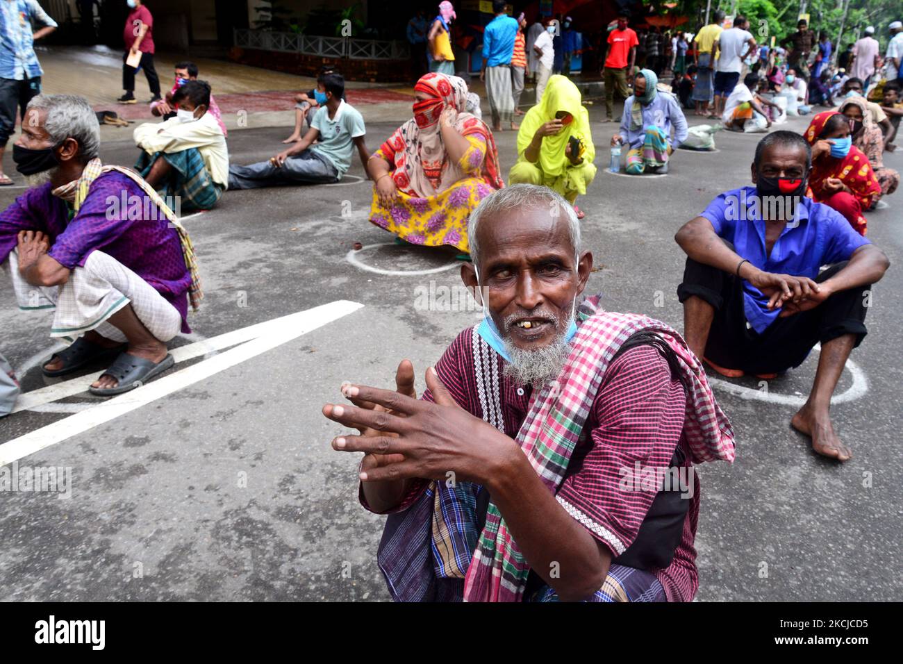 Poor people queue sit waits for receive food from Dhaka Metropolitan ...