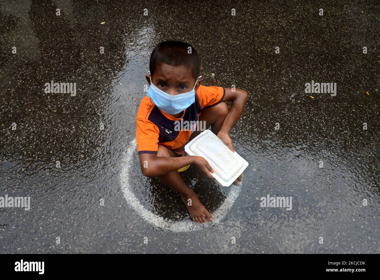 Poor people queue sits after receive food from Dhaka Metropolitan ...