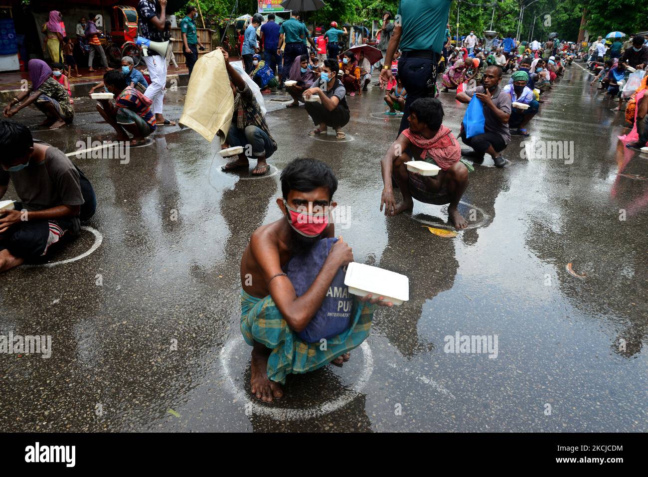 Poor people queue sits after receive food from Dhaka Metropolitan ...