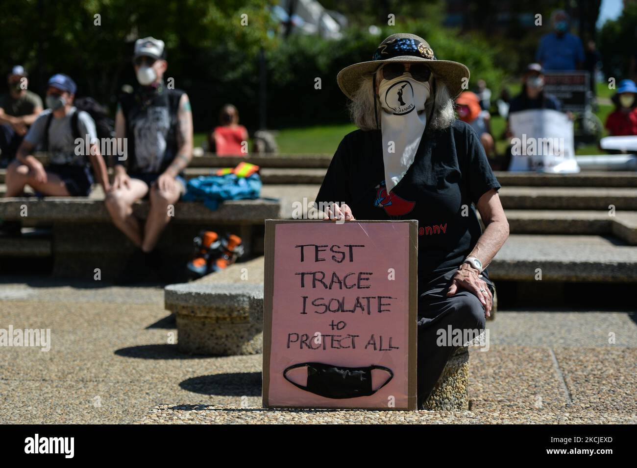An activist wearing a face cover seen holding a placard that reads ...