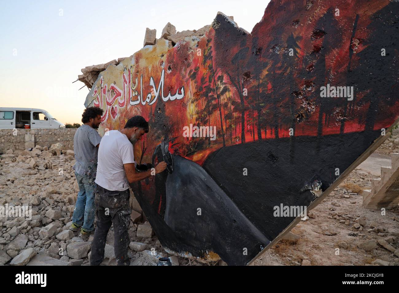 Artists Aziz Al-Asmar and Anis Saleh draw a painting representing the ...