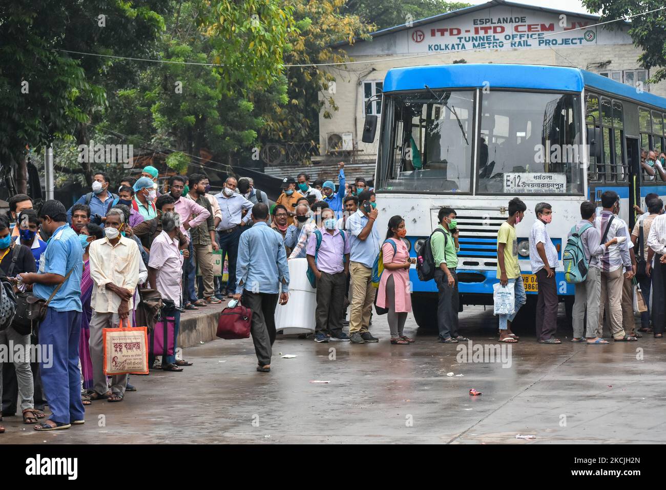 Commuters wait to board a bus , following no social distance norms ...