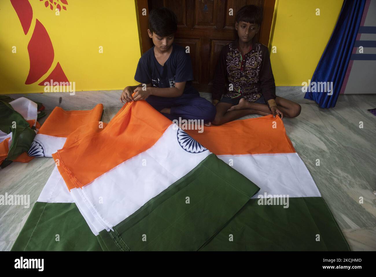 The boys are seen helping in packaging of the National Flags.The flag ...