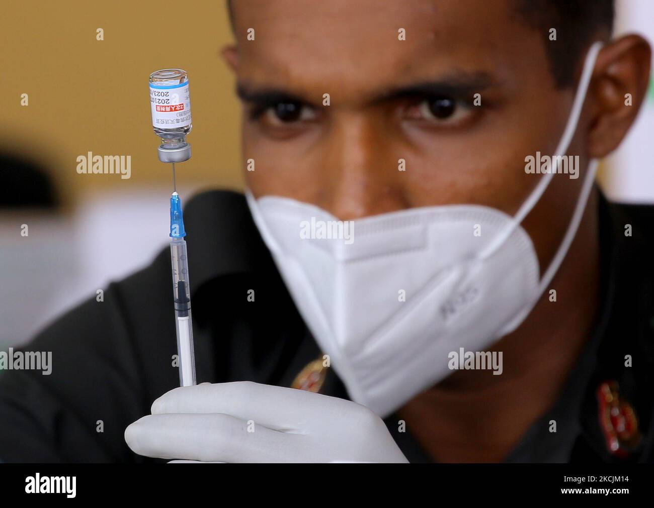 A Sri Lankan Army soldier attached to the medical unit loads a syringe ...