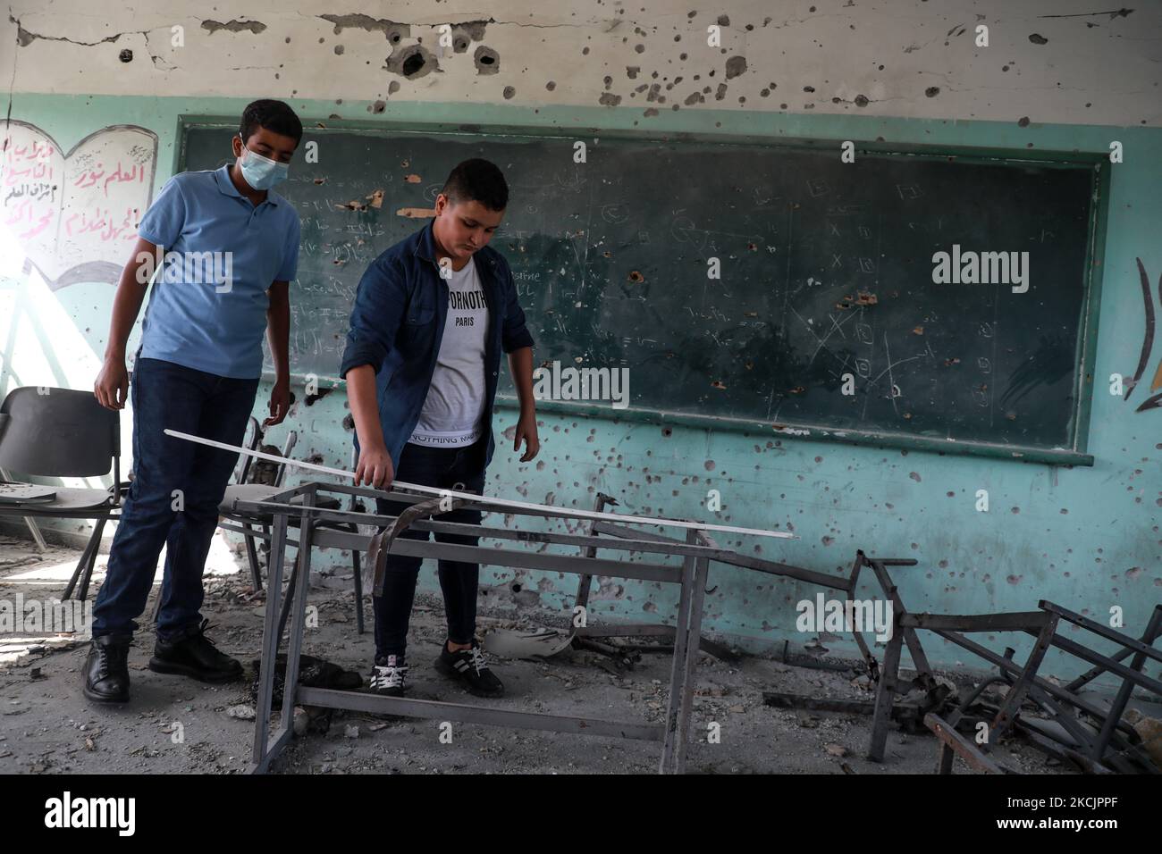 Palestinian students inspect a classroom at a school destroyed during ...