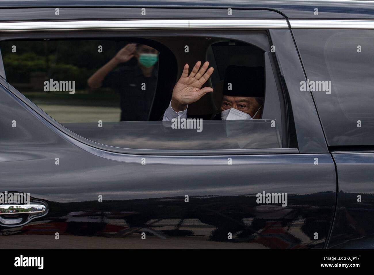 Malaysian Prime Minister Muhyiddin Yassin waves at members of the media ...