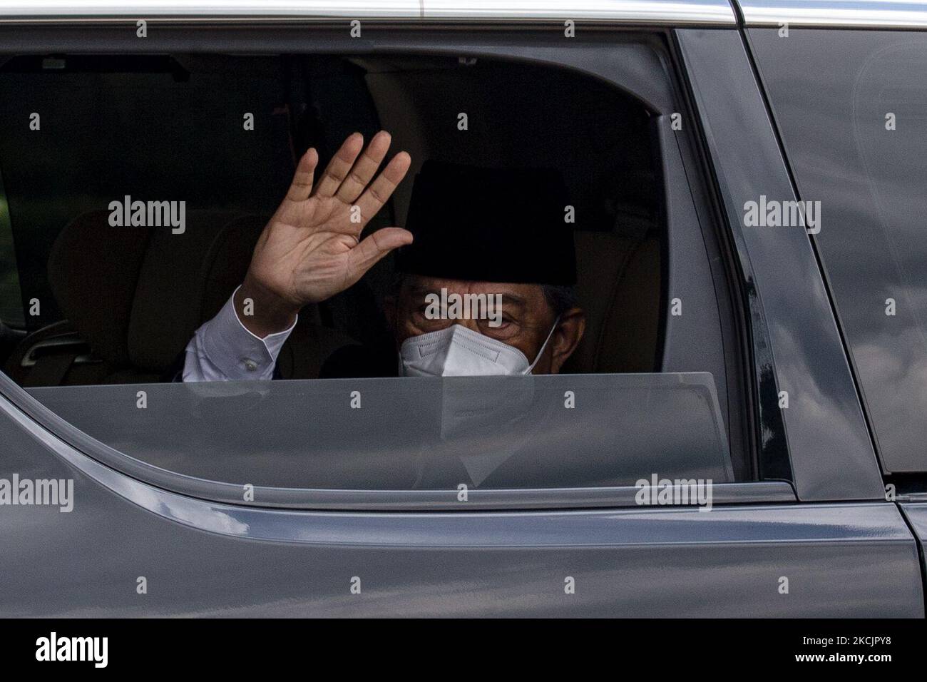 Malaysian Prime Minister Muhyiddin Yassin waves at members of the media ...