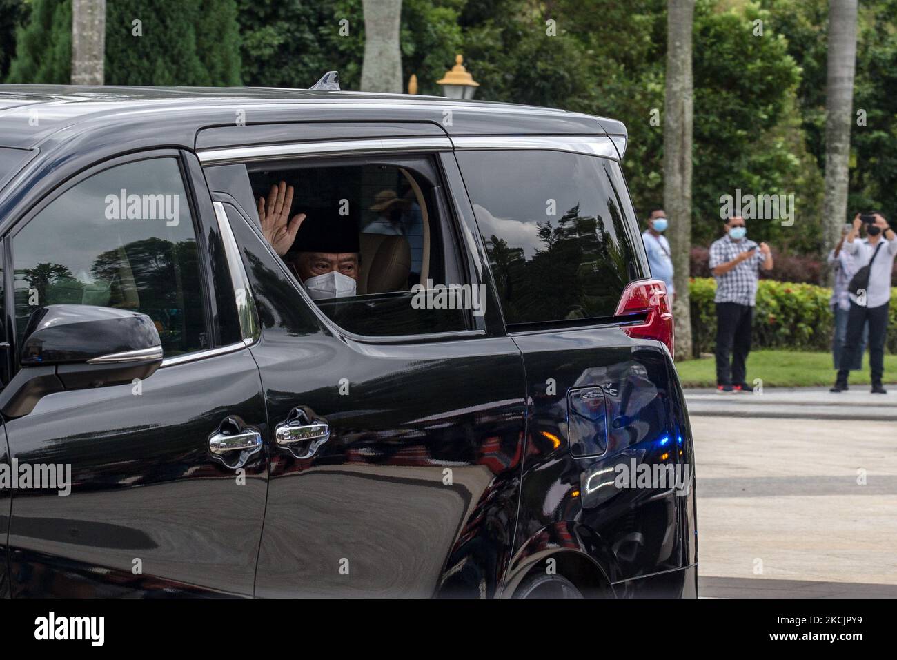 Malaysian Prime Minister Muhyiddin Yassin waves at members of the media ...
