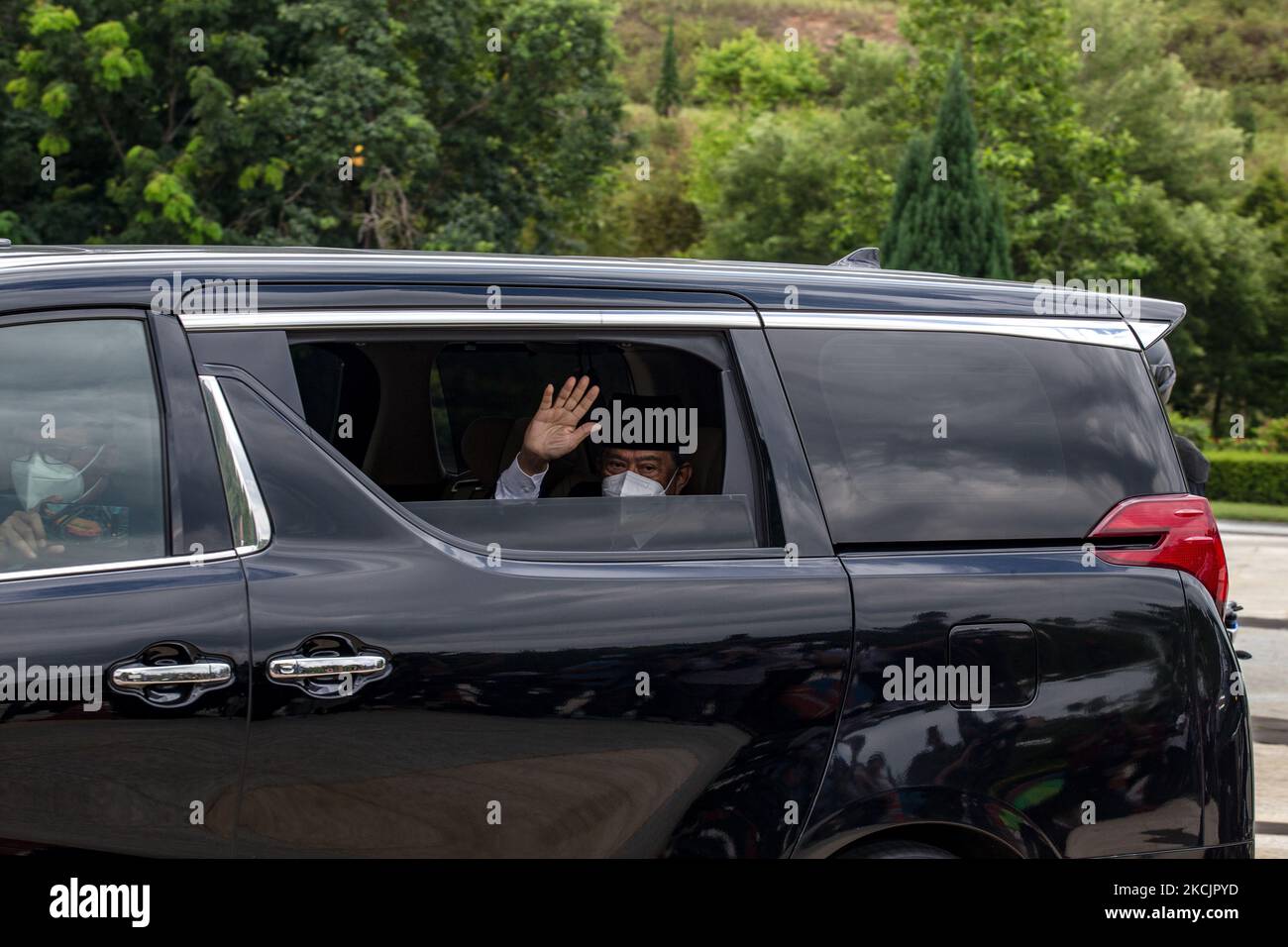 Malaysian Prime Minister Muhyiddin Yassin waves at members of the media ...