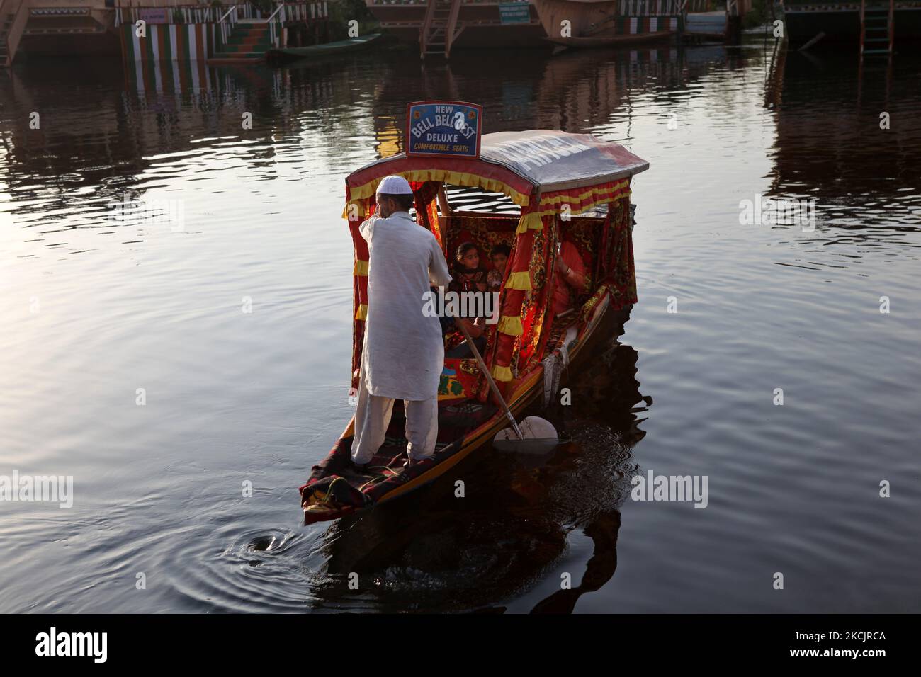 Shikara boatman ferries Indian tourists to their houseboat on Kashmir's ...