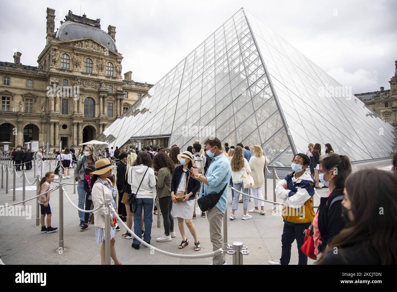 People queue to enter the Louvre Museum in Paris, France on July 16 ...
