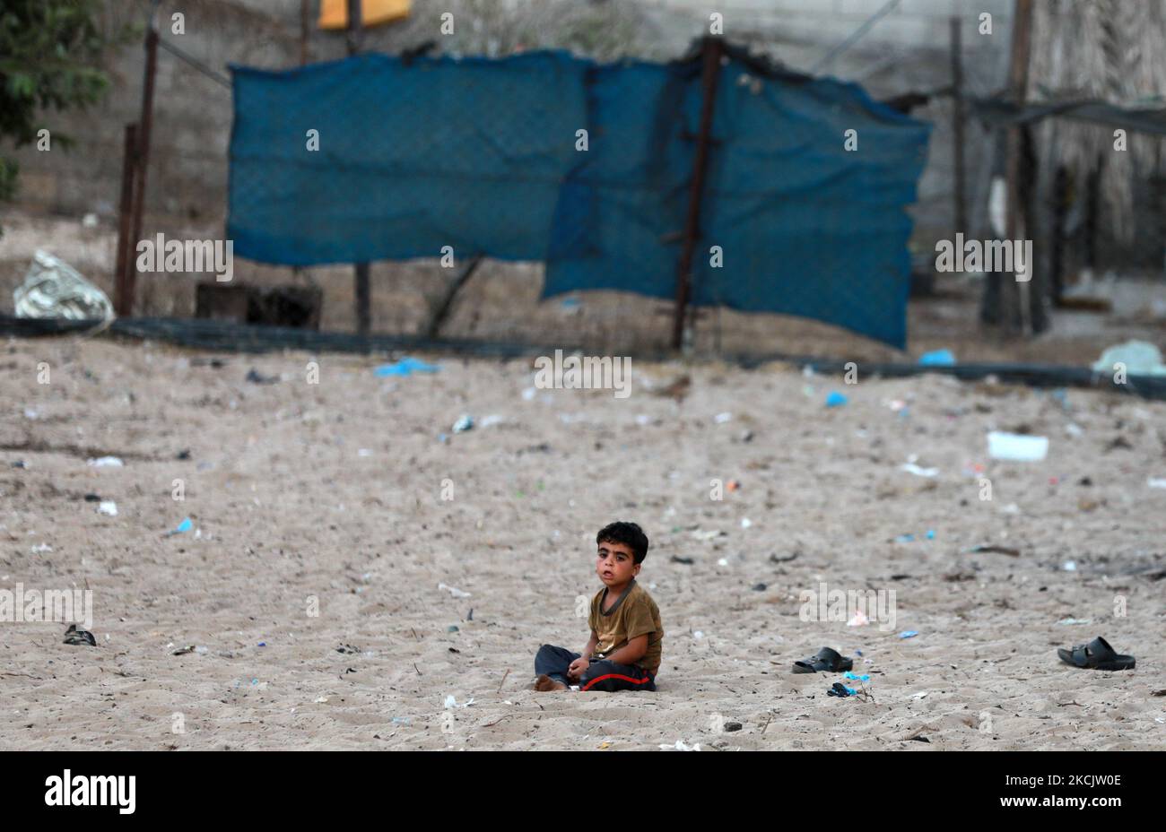 Palestinian child sits outside his house in a slum on the outskirts of ...