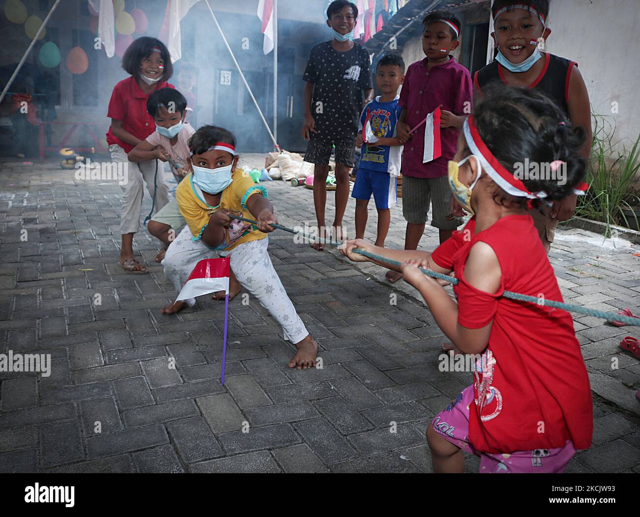 Several childrens are compete the traditional child game (pull the roop ...