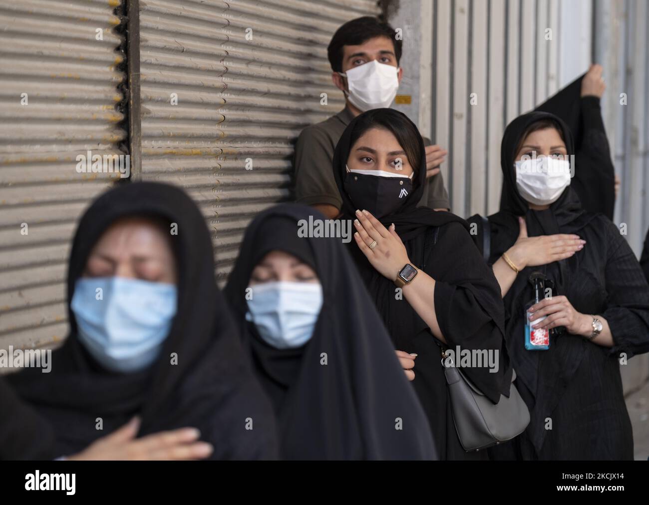 Iranian people wearing protective face masks beat themselves while ...