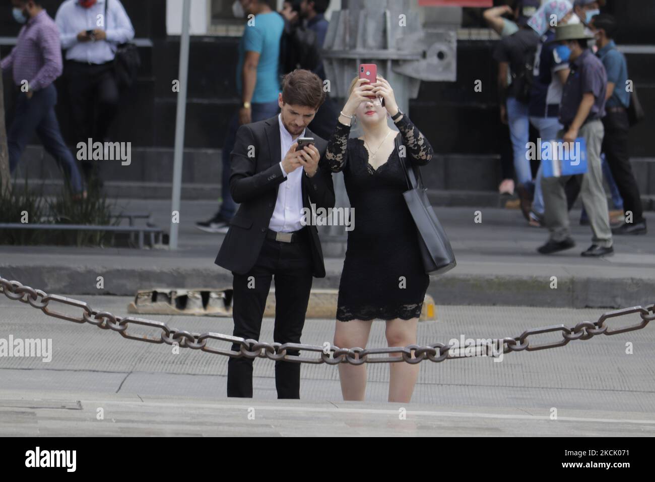 A couple takes photographs with their mobile phones on the esplanade of ...