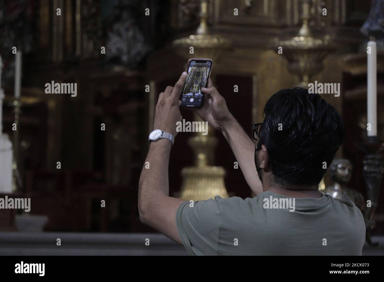 A person takes a photograph with his mobile phone inside a church in ...