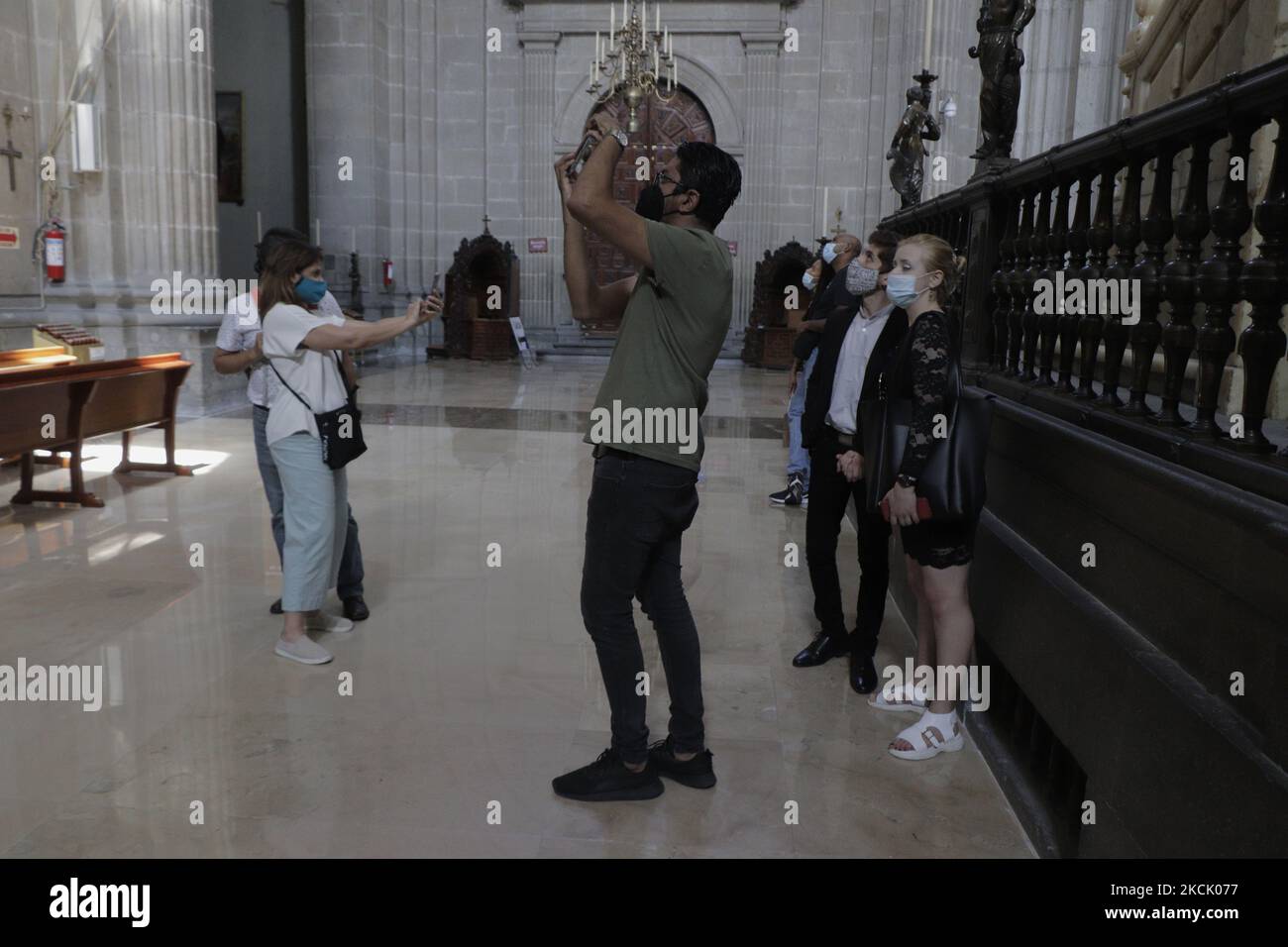 A person takes a photograph with his mobile phone inside a church in ...