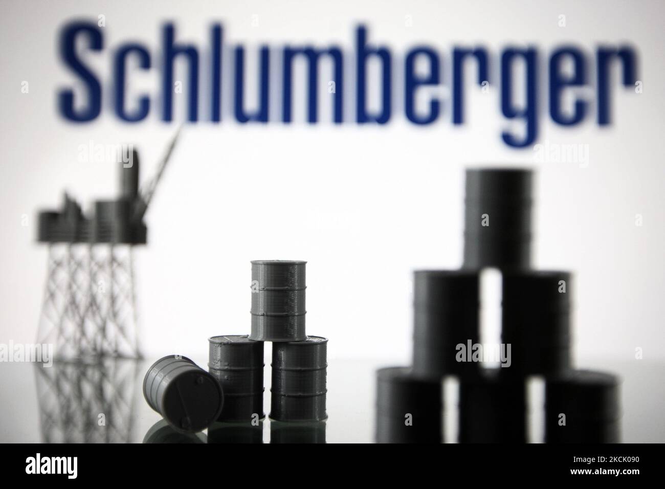 Schlumberger Limited logo and models of an oil rig and oil barrels are ...