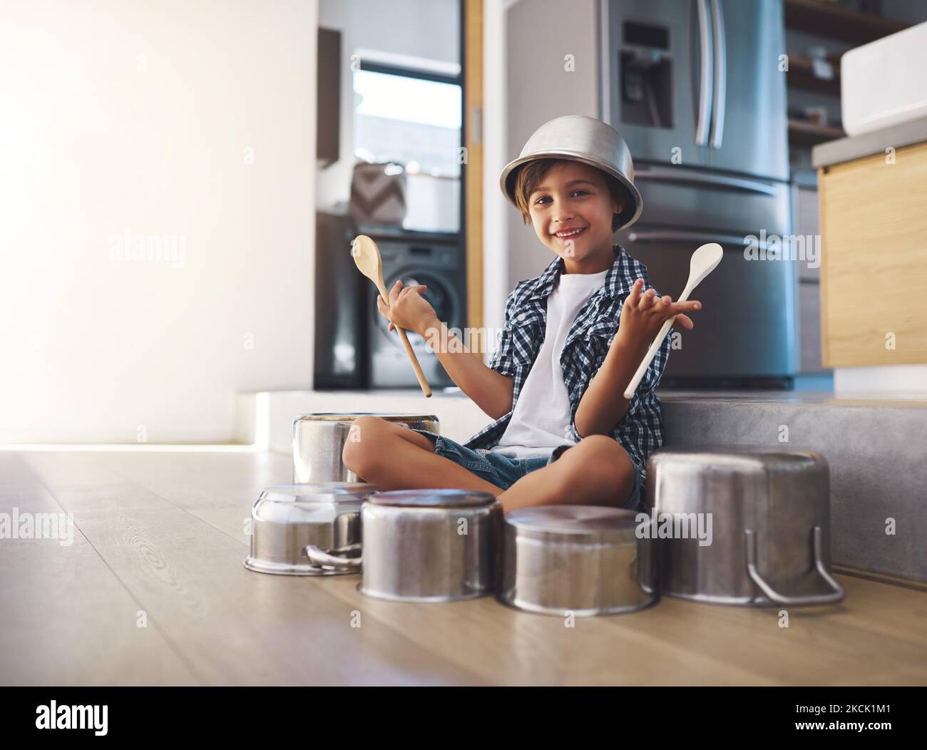 Stardom, here I come. Portrait of a happy little boy playing drums with ...