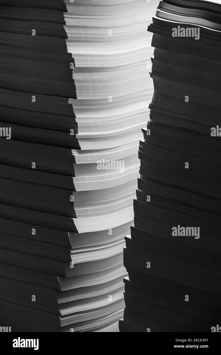 Piles of blank paper for printing illuminated with bright light in dark ...