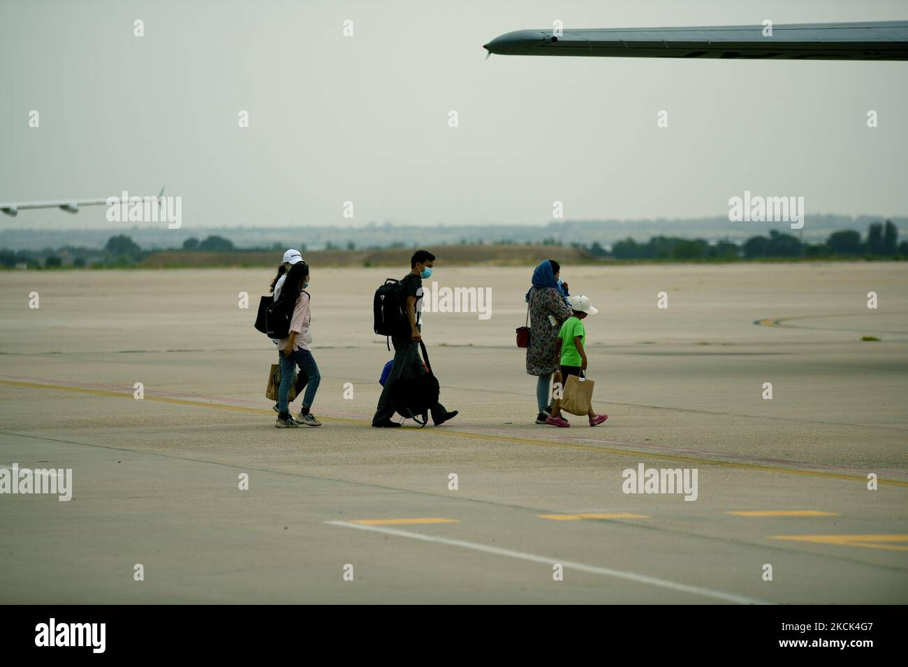 Afghan refugee queue to embark into a US air force plane at Torrejon ...