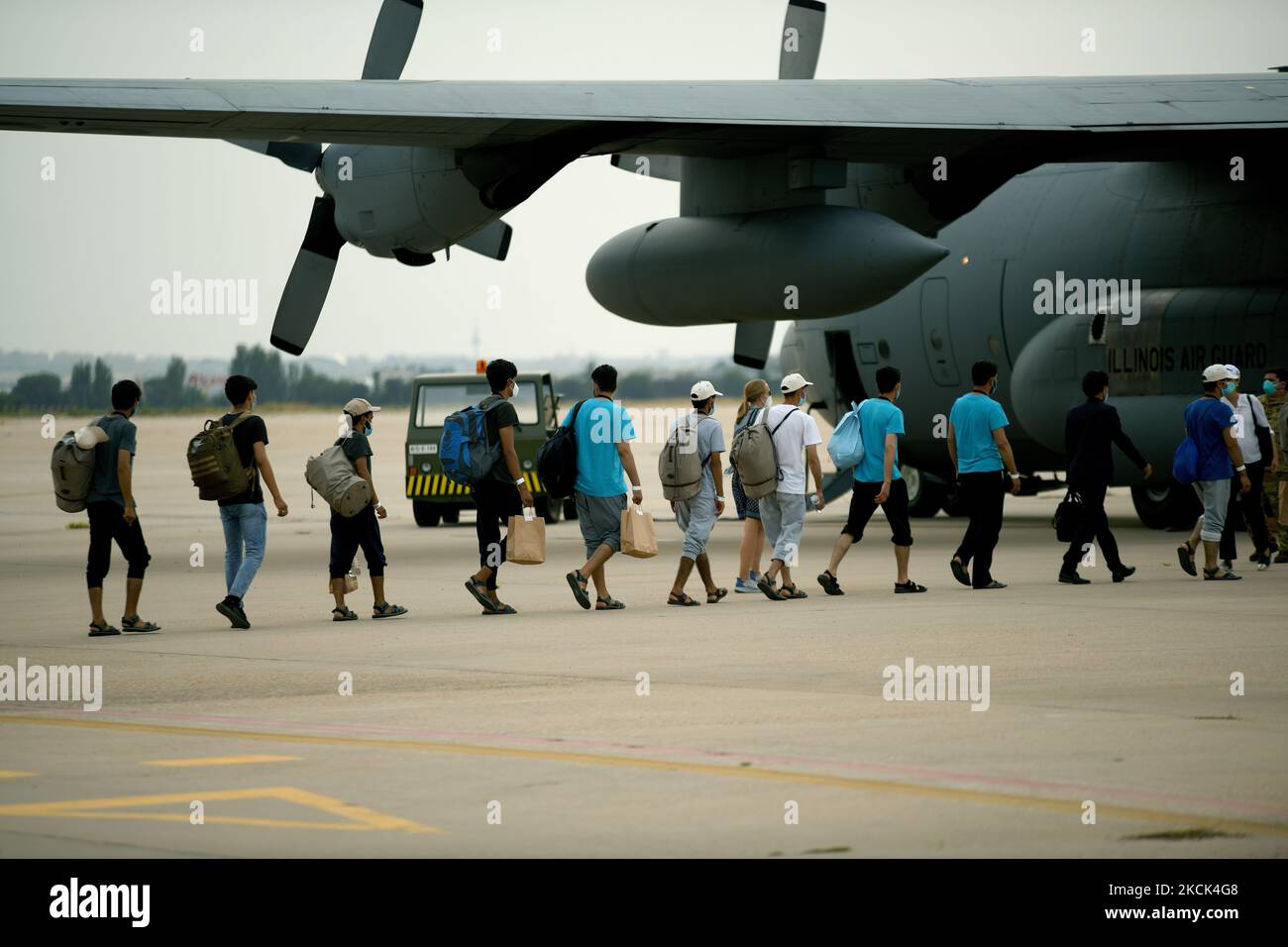 Afghan refugee queue to embark into a US air force plane at Torrejon ...