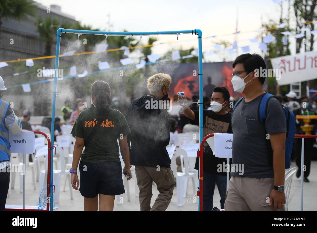 Protesters wearing a face mask walk past disinfectant dispensers and ...
