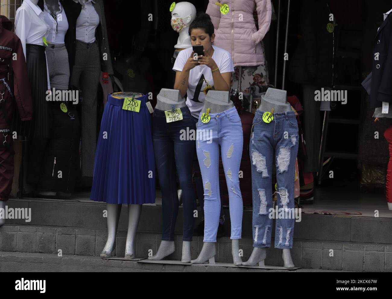 A woman leaning on several mannequins outside a dress shop in the ...