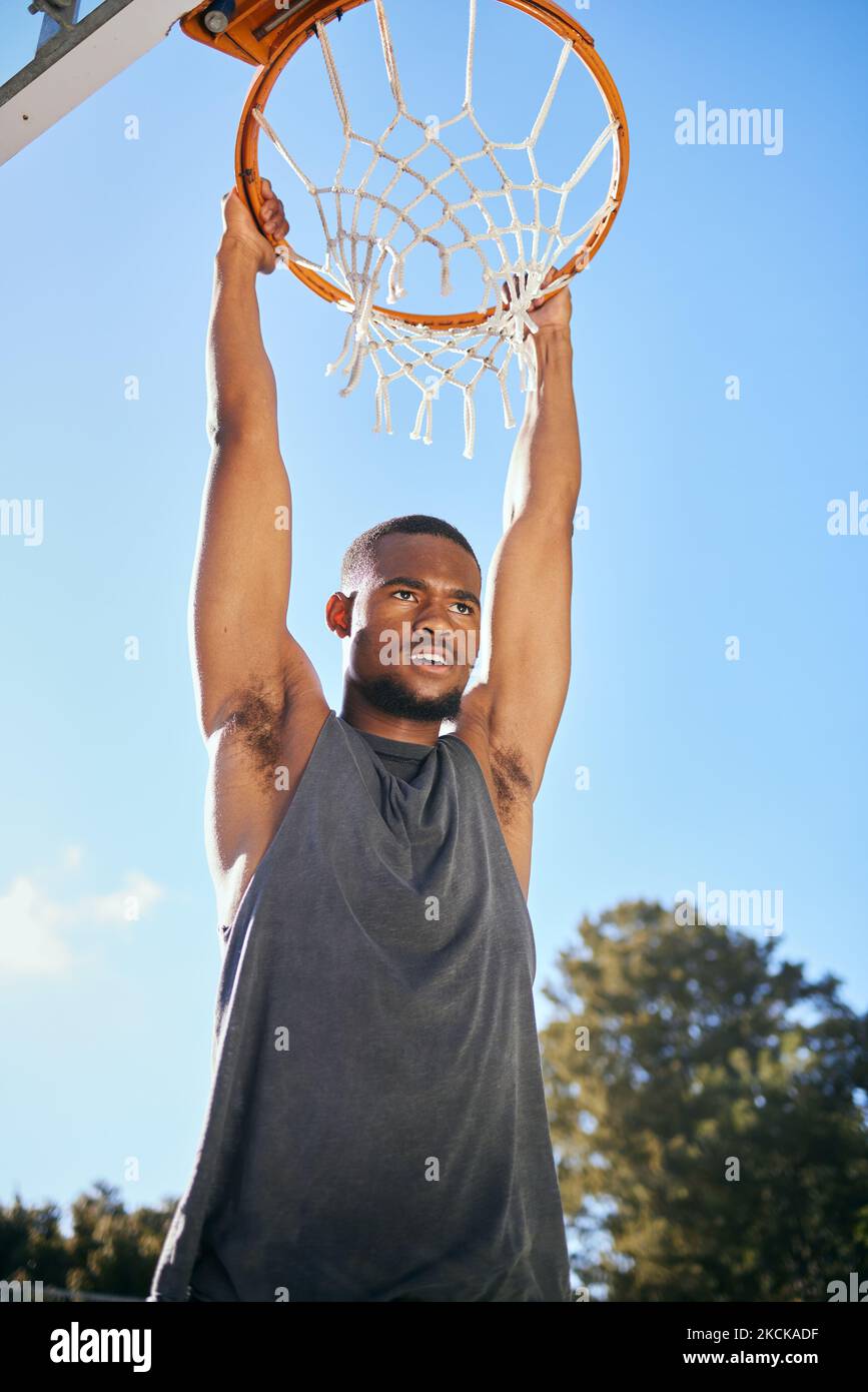 Basketball, sports and black man hanging on hoop at a game during ...