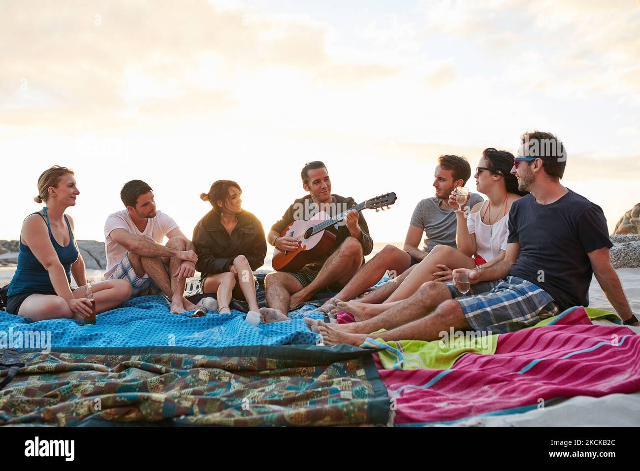 Chilling on the beach with his favorite audience. a group of happy ...