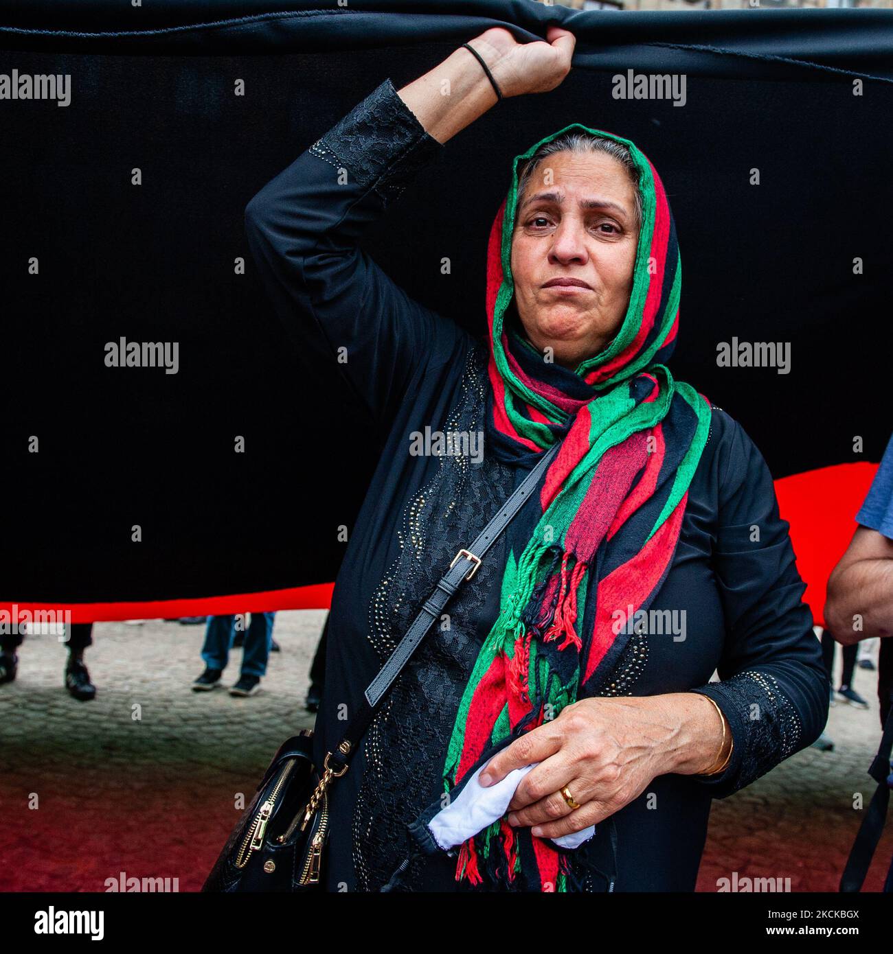 An Afghan woman is crying while holding a big Afghan flag, during the ...