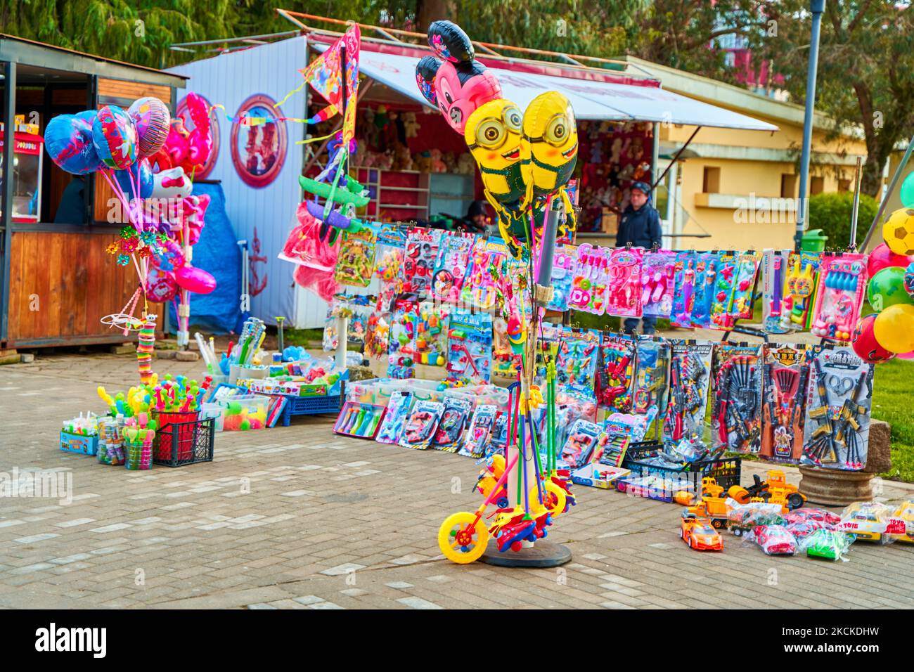 A street vendor's counter with balloons and all sorts of toys for ...