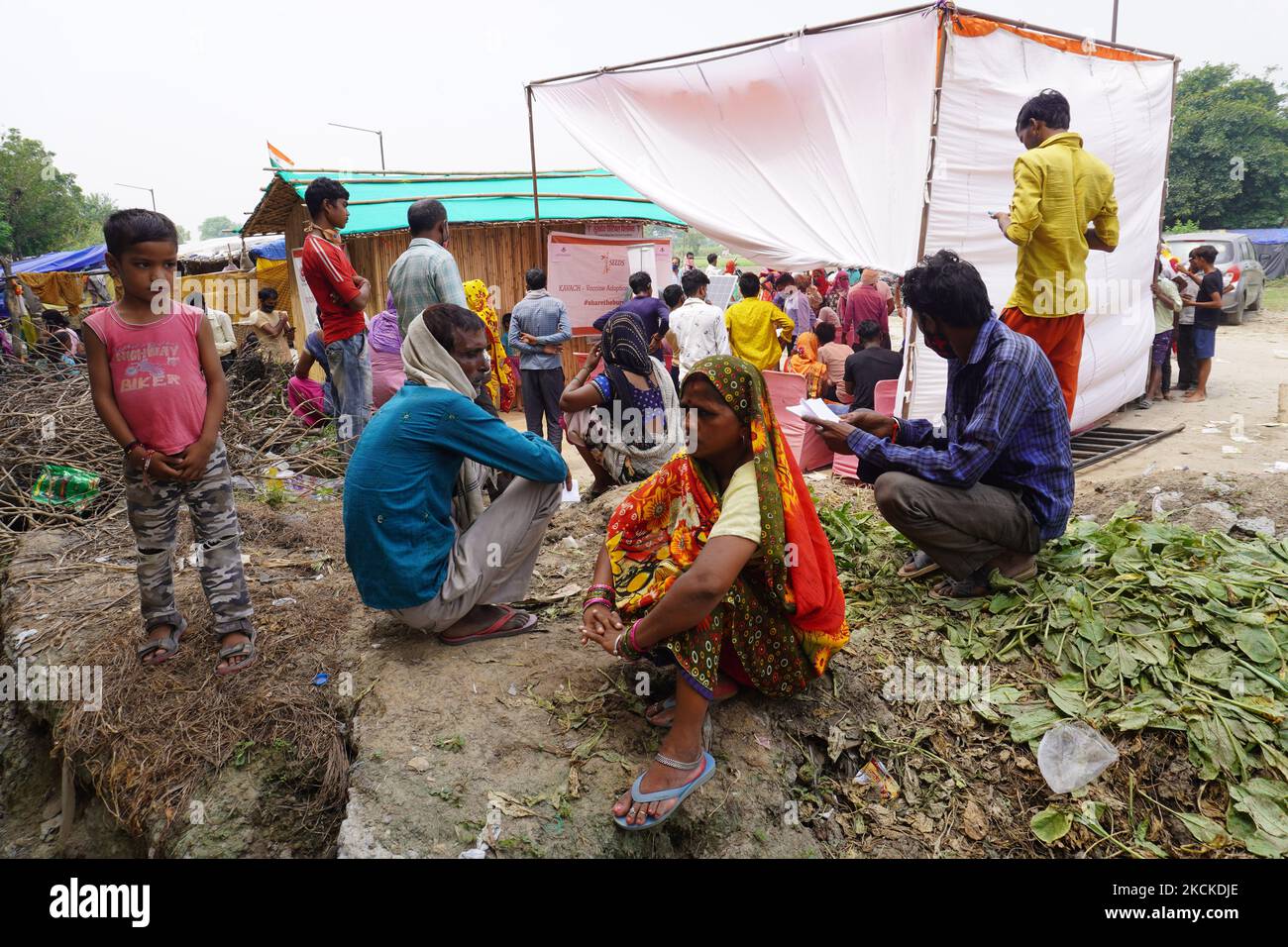 People wait after registering themselves to get inoculated with a dose ...