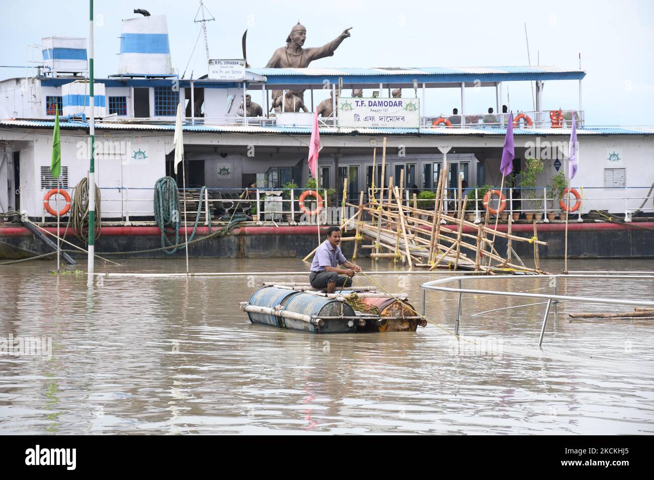 :A man use a makeshift raft in flood water caused by heavy rain and ...