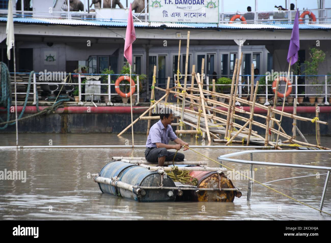 :A man use a makeshift raft in flood water caused by heavy rain and ...