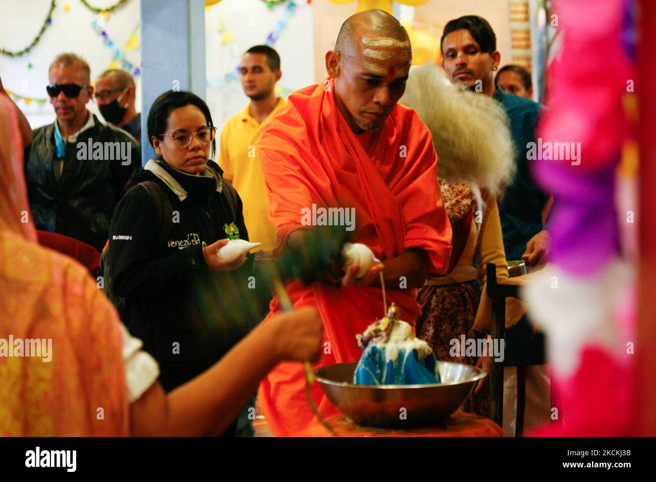 A devotee makes an offering during 'Janmashtami' festival to celebrate ...