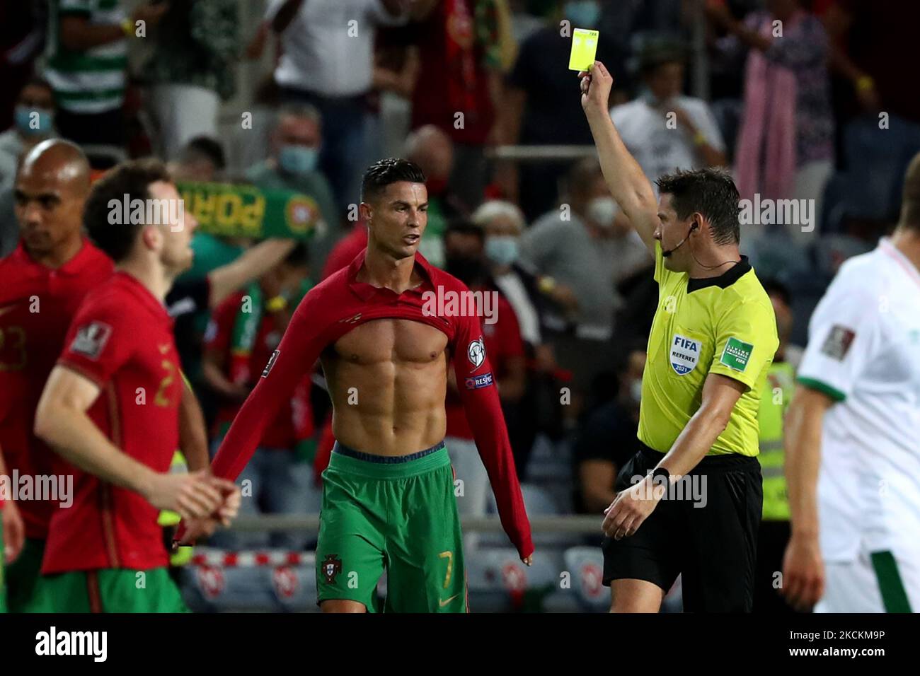 Referee Matej Jug of Slovenia shows a yellow card to Portugal's forward Cristiano Ronaldo (C ...