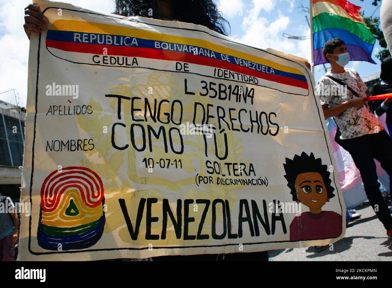 LGBTIQ+ activist holds a banner simulating the Venezuelan identity card ...