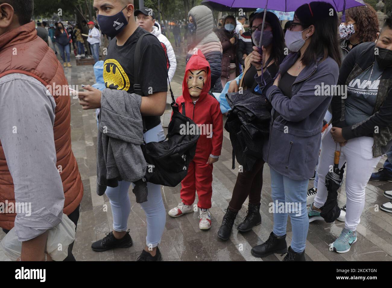 A boy wearing red overalls and a mask of Salvado Dalí, in front of the ...