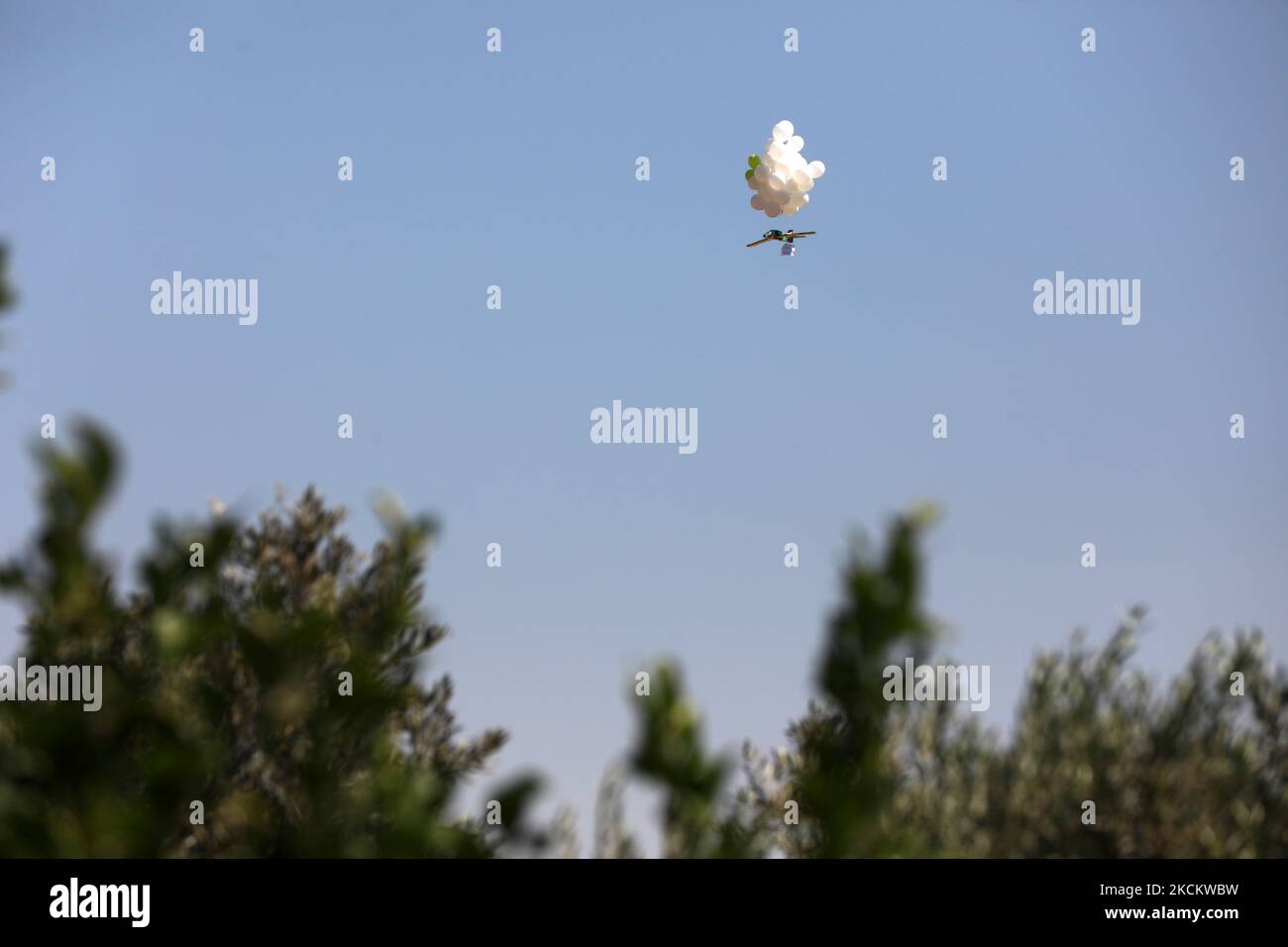 Masked Palestinian supporters of the Hamas movement prepare balloons ...