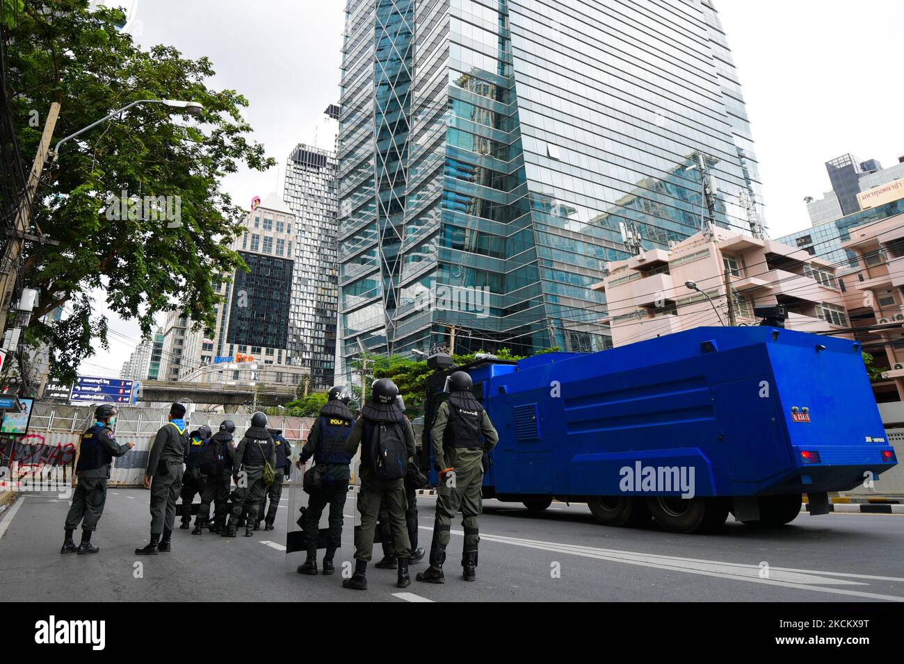 Riot police officers stand beside a water cannon truck as riot police ...