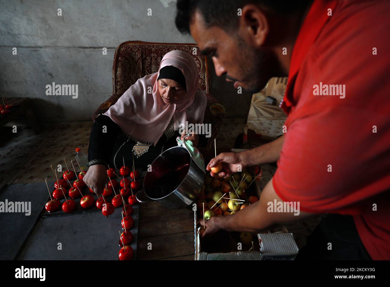 Palestinian Hanan Hamad, 50, makes candy apples with colored honey ...