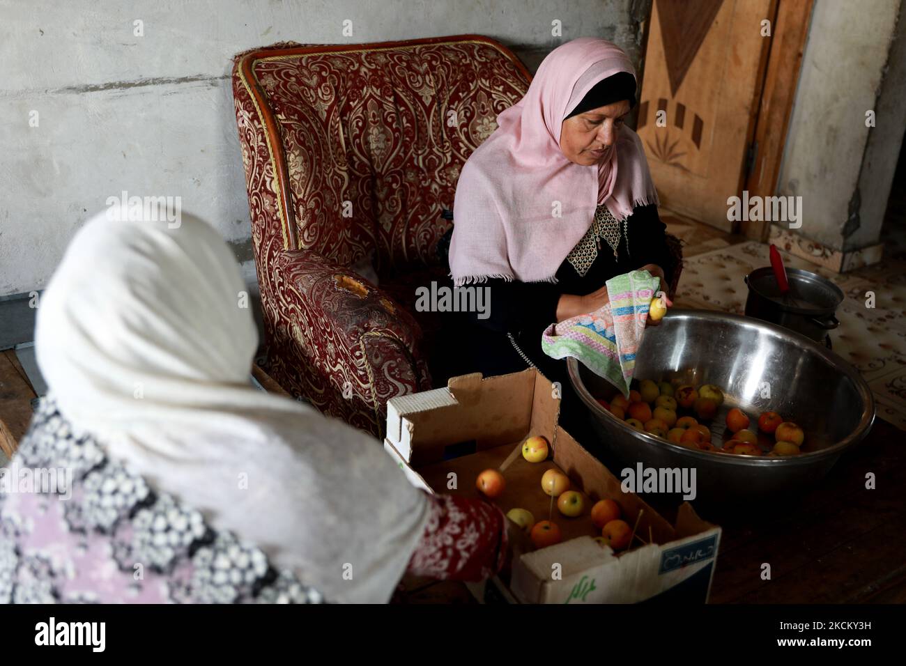 Palestinian Hanan Hamad, 50, makes candy apples with colored honey ...