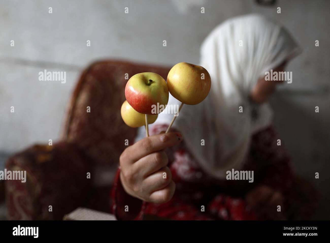 Palestinian Hanan Hamad, 50, makes candy apples with colored honey ...