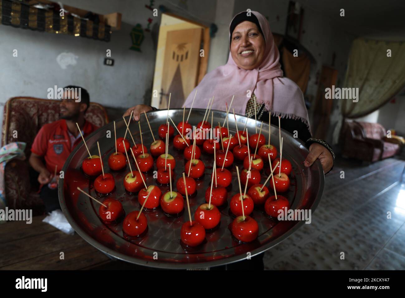 Palestinian Hanan Hamad, 50, makes candy apples with colored honey ...